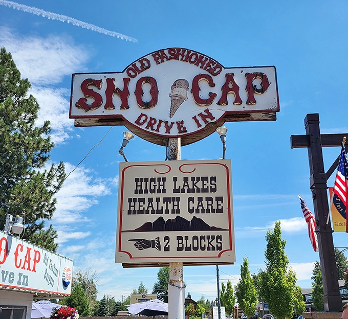 The vintage roadside sign stands as a beacon of hope for hungry travelers—promising salvation in the form of burgers and ice cream.