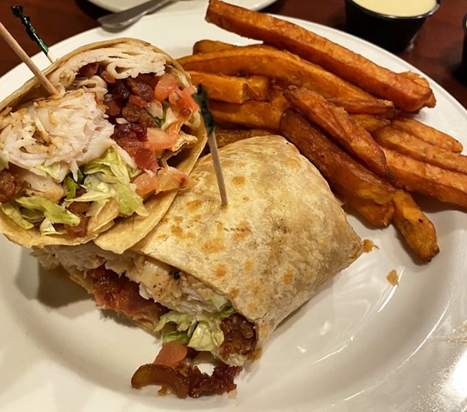 A wrap that refuses to be the boring option on the menu. Those sweet potato fries aren't sidekicks—they're co-stars in this lunch production.