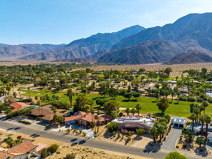 An aerial view reveals Desert Hot Springs' perfect balance – green golf courses and palm-lined streets surrounded by the raw beauty of desert wilderness.