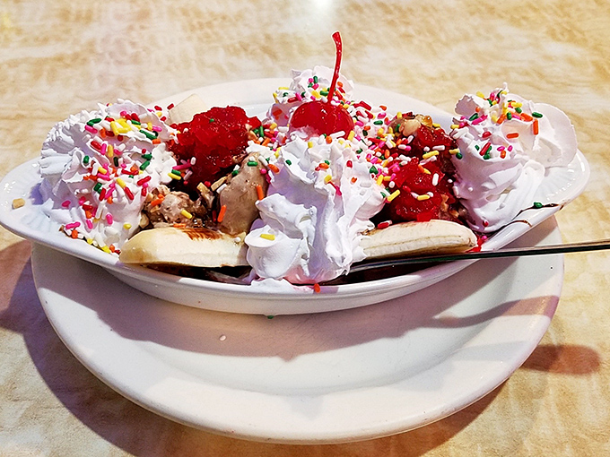 This banana split isn't dessert—it's a celebration with whipped cream confetti, sprinkle streamers, and cherries on top.