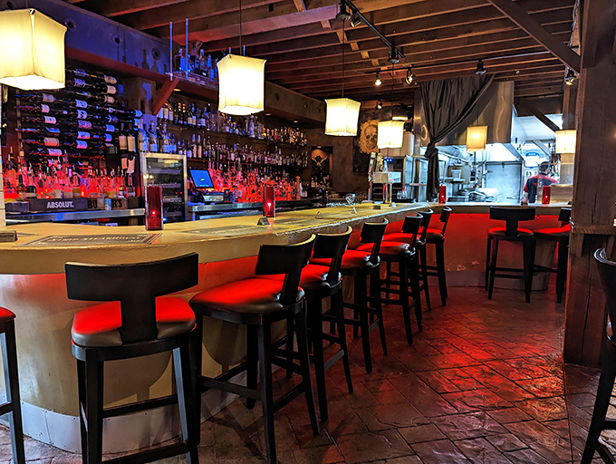 Bar stools that beckon like old friends. The crimson glow isn't just mood lighting—it's the warm blush of anticipation for what's to come.