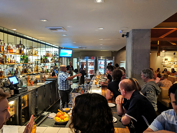 The bustling bar scene—where strangers become friends and cocktails flow freely. The energy here is as intoxicating as what's in the glasses.