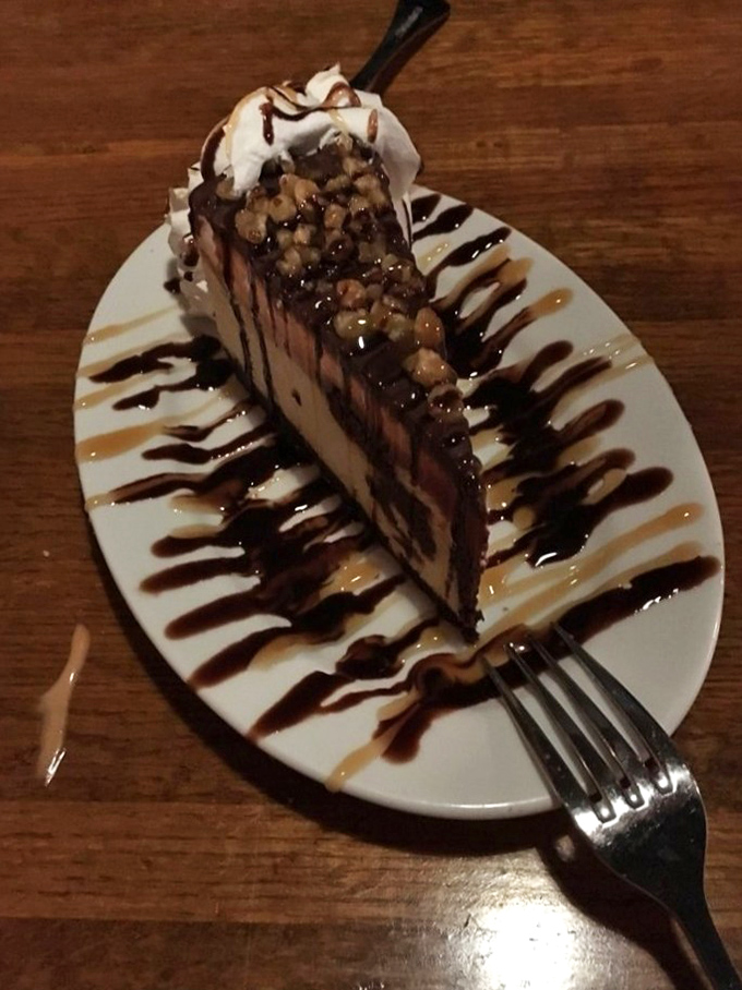 This isn't just cheesecake; it's architecture with calories. The chocolate and caramel drizzles aren't decoration—they're essential infrastructure.