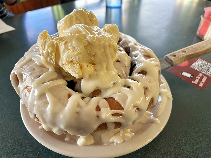 Behold the star attraction—a cinnamon roll so magnificent it deserves its own ZIP code. That icing doesn't drip, it cascades.