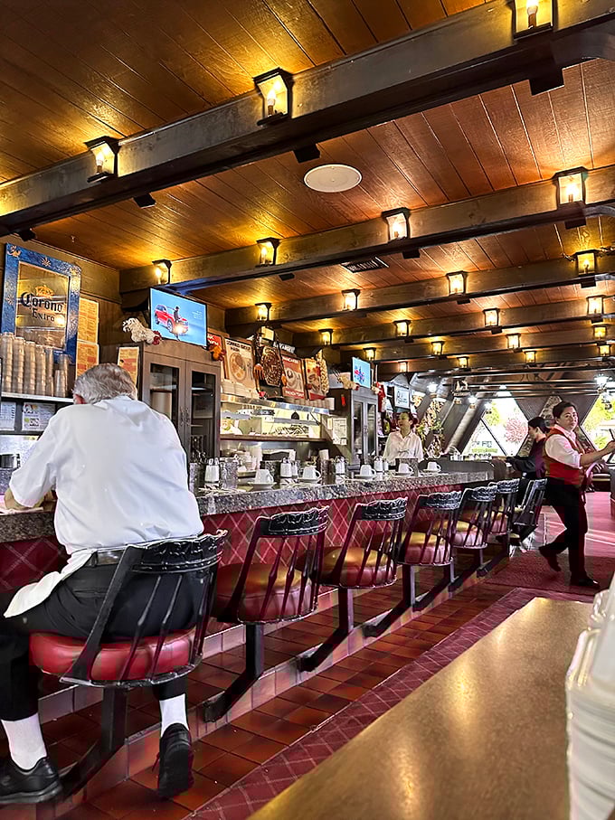 The counter—where breakfast magic happens. Those red stools have witnessed countless coffee refills and "just one more pancake" negotiations over the years.