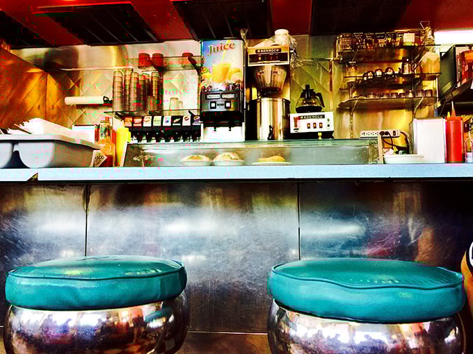 Those turquoise counter stools pop against the metallic backdrop like jewels, inviting you to perch and ponder life's big questions over a slice of pie.