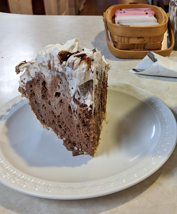 Chocolate pie that makes grown adults consider licking the plate. The whipped cream isn't decoration—it's the cloud you'll float away on.