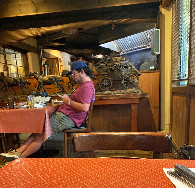 Every table tells a story, every bite creates a memory, and somewhere in the background, a stagecoach sculpture reminds you of simpler, beefier times.