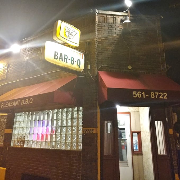 As night falls, the illuminated sign of MT Pleasant Bar-B-Q glows like a barbecue beacon, drawing in those wise enough to follow its siren call.