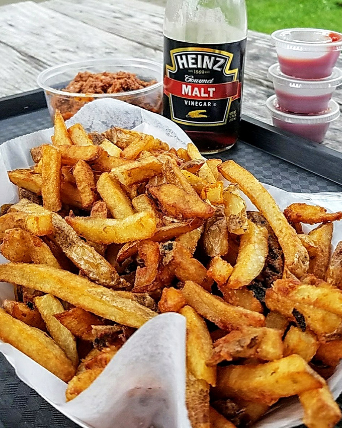 Fries so perfectly golden they deserve their own Instagram account. That bottle of malt vinegar standing by is no accident—it's tradition waiting to happen.