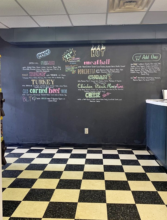 The chalkboard menu wall – where sandwich dreams are written before becoming delicious reality. That floor is pure old-school deli perfection.