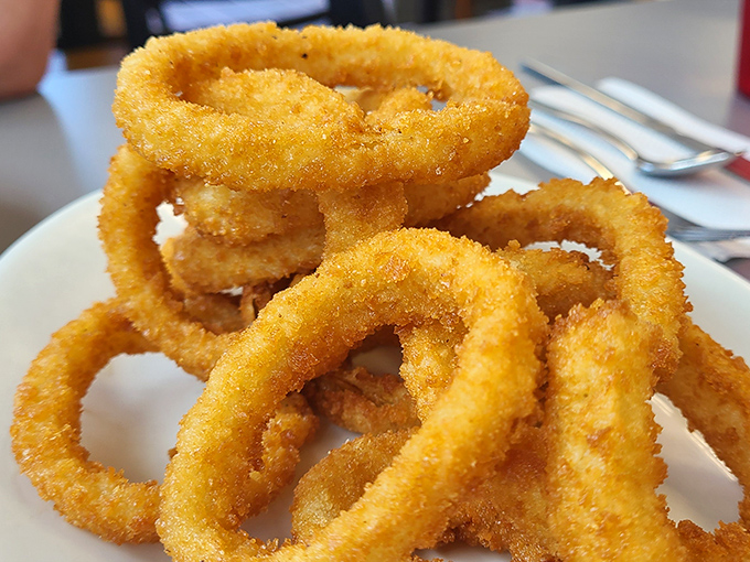 Onion rings with the structural integrity of Olympic gold—crispy armor protecting sweet, tender onion that surrenders at first bite.