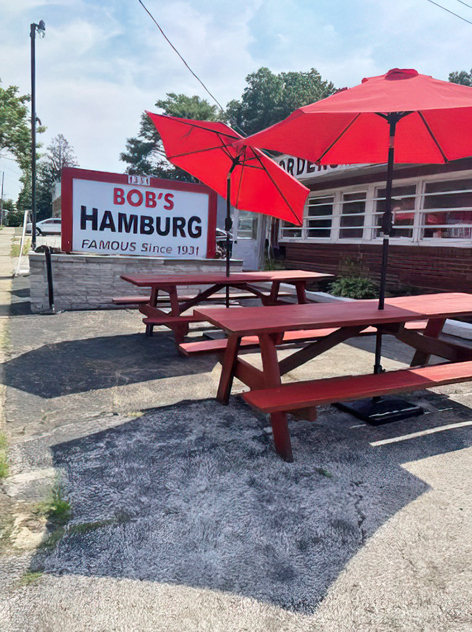 Those red picnic tables under bright umbrellas aren't just outdoor seating—they're community gathering spots where summer memories are made between bites of perfect burgers.