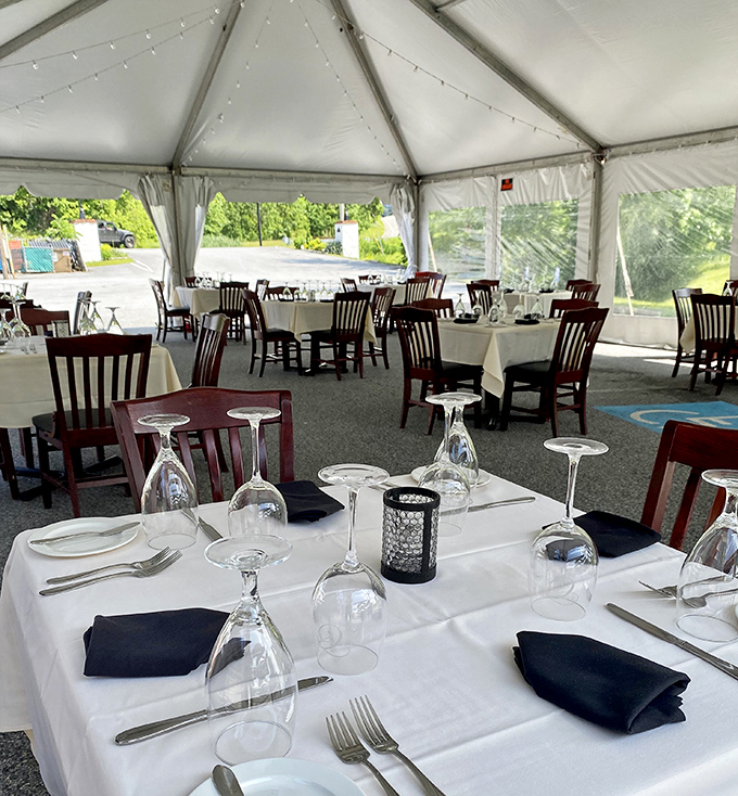 Outdoor dining under crisp white tents—where summer evenings stretch longer and wine somehow tastes better in the fresh air.