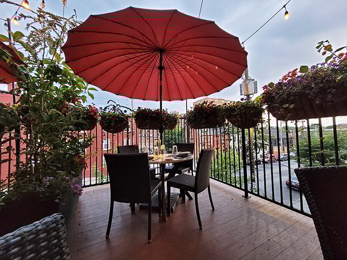 The outdoor dining area offers a secret garden escape. That red umbrella isn't just shade—it's a signal that something special happens here.
