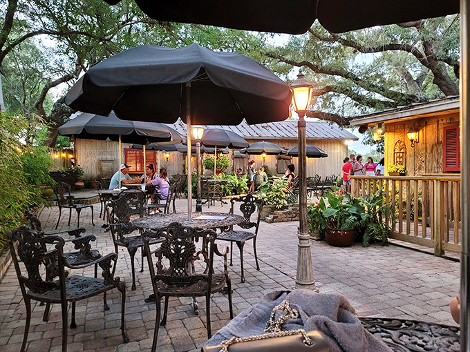 As evening falls, the patio transforms into a magical dining oasis. String lights twinkle overhead while conversations and laughter blend with harbor sounds.