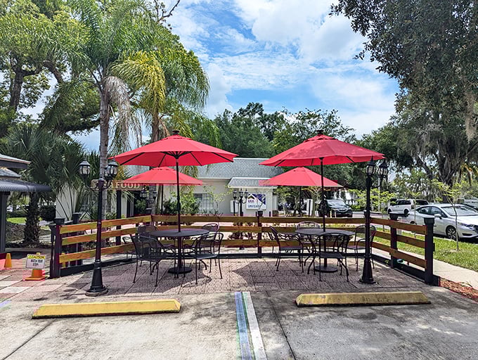 The outdoor seating area offers Florida sunshine with your seafood. Those red umbrellas aren't just for shade—they're beacons for hungry travelers.