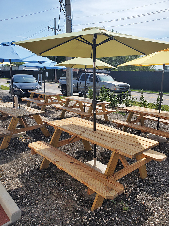 Outdoor picnic tables under cheerful yellow umbrellas—because sometimes barbecue just tastes better with a side of sunshine and fresh air.