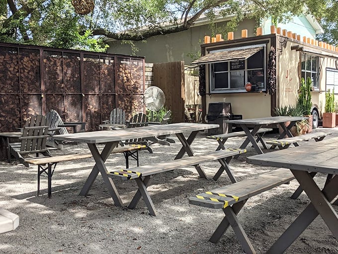 The outdoor seating area—where picnic tables await under dappled shade, ready for the serious business of Texas-style feasting.