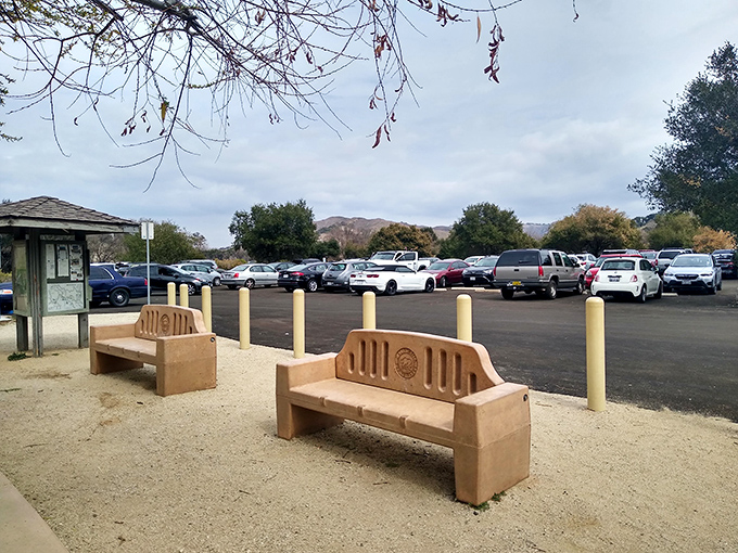 The journey begins at this unassuming parking area. Don't let the ordinary entrance fool you—extraordinary adventures await just beyond those mountains.