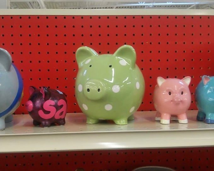 The piggy bank lineup—each one silently competing to be your new change collector while adding a pop of whimsy to your bookshelf.