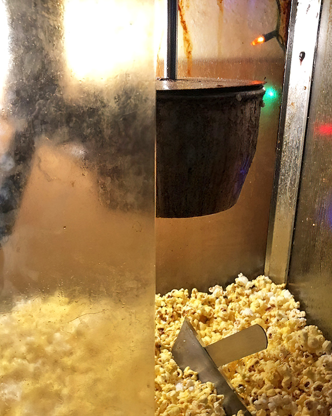 Free popcorn while you wait—because the only thing better than anticipation is anticipation with a snack. Pure genius.