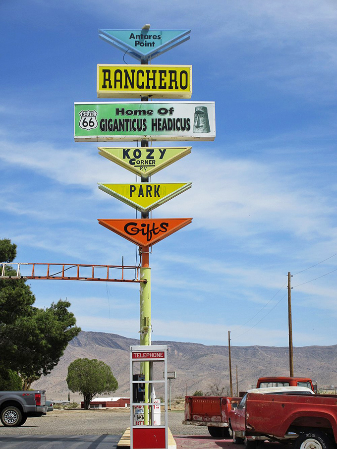The vintage sign tower serves as a roadmap to happiness: Ranchero, Giganticus Headicus, Kozy Corner, Park, and Gifts – everything a traveler needs.