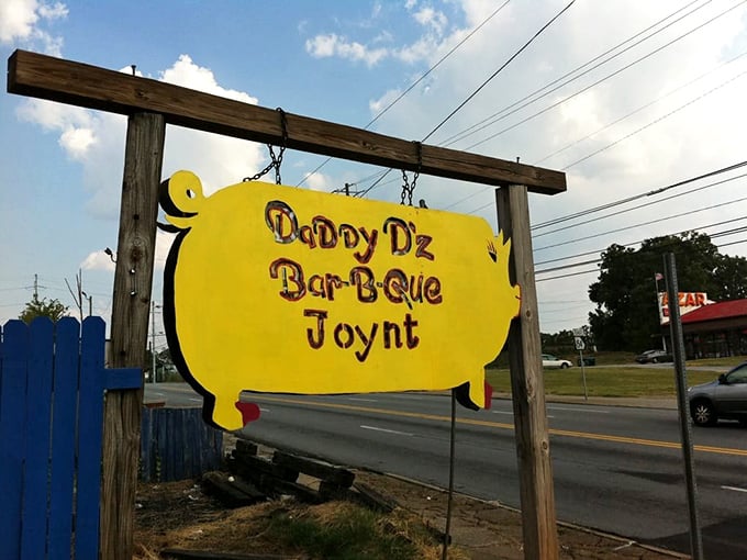 Yellow pig sign beckoning from the roadside – like a BBQ lighthouse guiding hungry travelers to smoky salvation.
