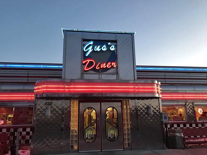 As night falls, Gus's neon sign glows like a beacon for hungry travelers – a promise of comfort food that transcends time in Sun Prairie.