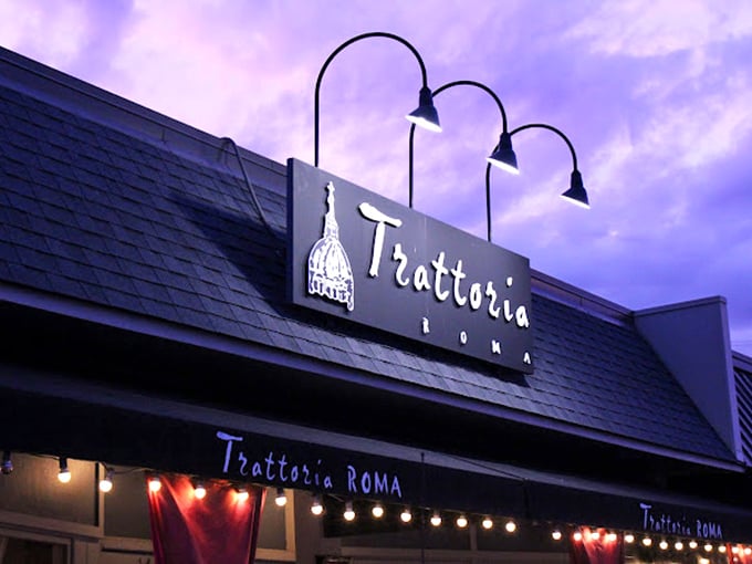 As dusk falls, the Trattoria Roma sign glows against the purple sky, a beacon of culinary promise that's impossible to resist.