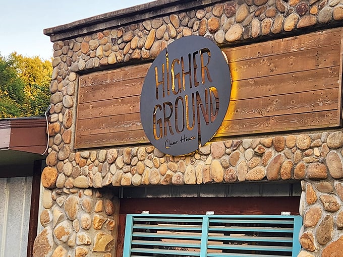 The entrance sign combines rustic stone with modern design promises exactly what awaits inside—elevated comfort food that lifts your spirits as much as it satisfies your hunger.