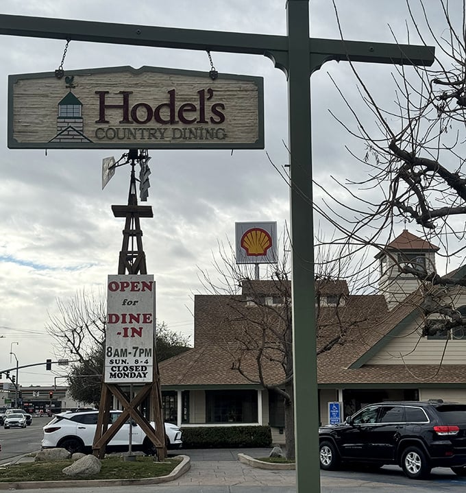 The rustic wooden sign swinging gently in the Bakersfield breeze—a beacon of hope for hungry travelers and a landmark for locals who know what awaits inside.