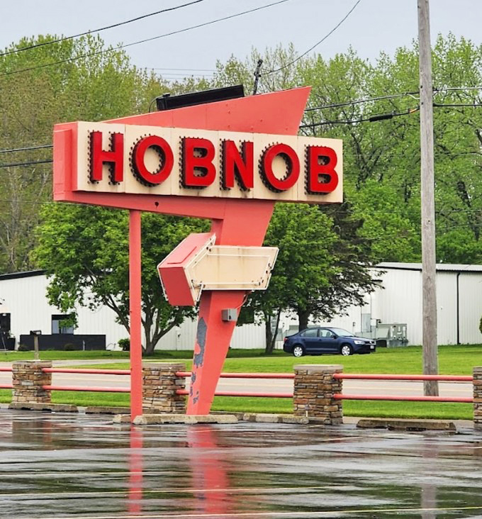The roadside sign stands proud against Wisconsin skies – a landmark that's guided hungry travelers to exceptional meals for decades.