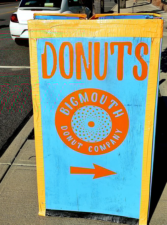 This cheerful sidewalk sign points the way to happiness with the subtlety of a sugar rush—bold, bright, and impossible to ignore.