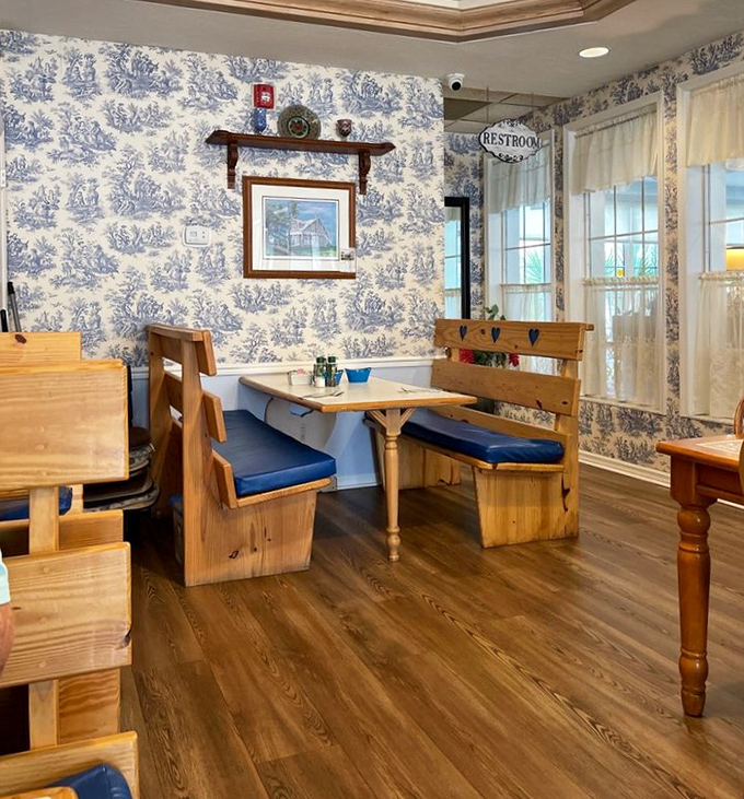 Blue toile wallpaper and wooden booths create a corner that feels like dining in your favorite aunt's country home—if your aunt were an exceptional cook.