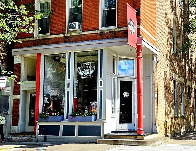 The charming storefront of Butcher & The Burger beckons with its classic red brick and inviting windows. A carnivore's paradise hiding in plain sight!