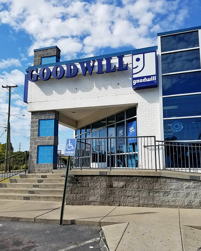 The blue Goodwill sign beckons like a lighthouse to treasure hunters. This bin paradise promises adventures by the pound!