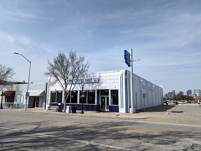 The iconic white exterior of Paris Coffee Shop beckons like a breakfast beacon in Fort Worth. History and hotcakes await inside!