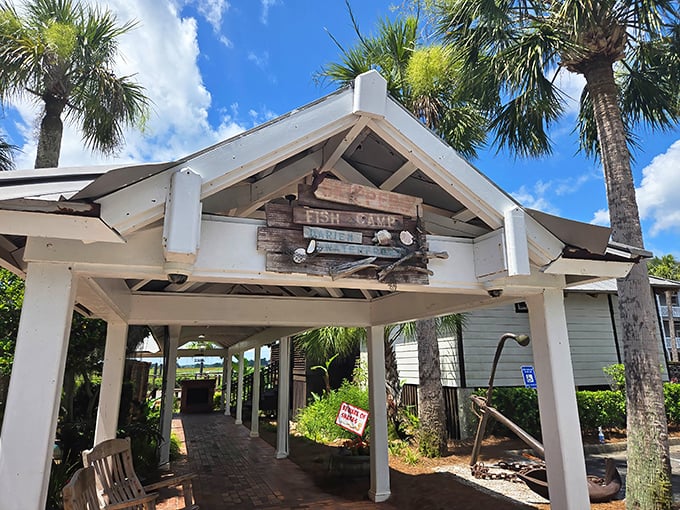 The entrance to Skipper's Fish Camp beckons like a coastal siren. Palm trees, white columns, and that wooden sign promising seafood adventures ahead!