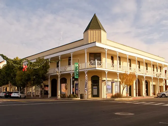 This gorgeous corner building whispers stories from another era. Imagine the conversations that have happened on that beautiful wraparound balcony!