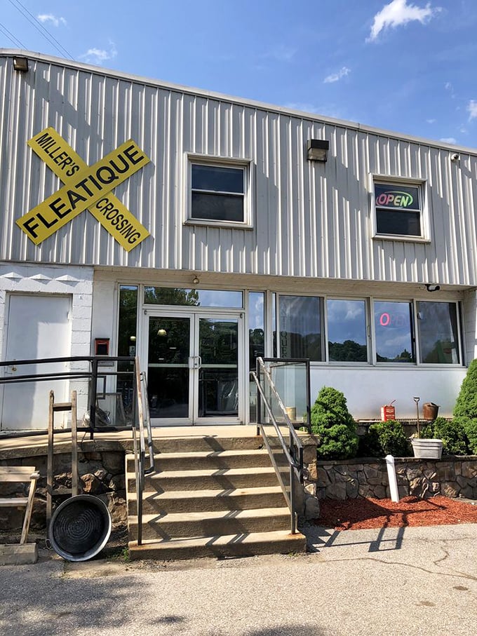 The unassuming entrance belies the wonderland within. That yellow railroad sign isn't just decoration—it's your first clue to the adventure ahead.
