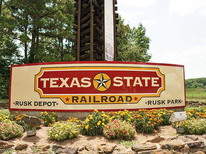This isn't just a sign—it's your official invitation to step back in time. The colorful flower beds add a touch of warmth to the historic welcome.