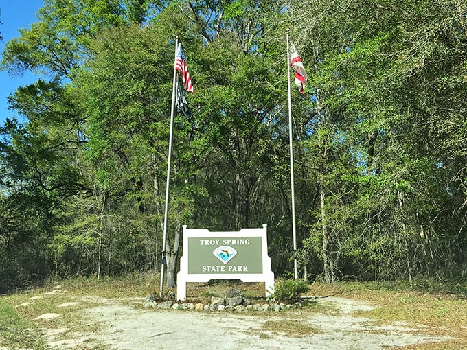 The entrance sign stands like a humble gatekeeper to paradise. No velvet rope, no dress code—just 70 feet of pristine spring water beyond.
