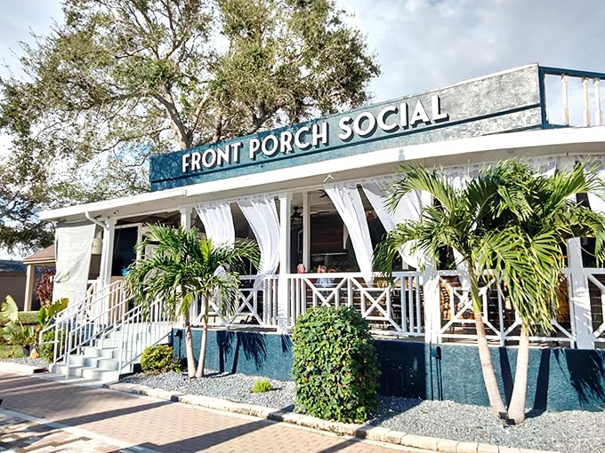 Front Porch Social isn't just a name—it's a lifestyle philosophy. White railings, tropical plants, and that Florida breeze make every meal feel like vacation.