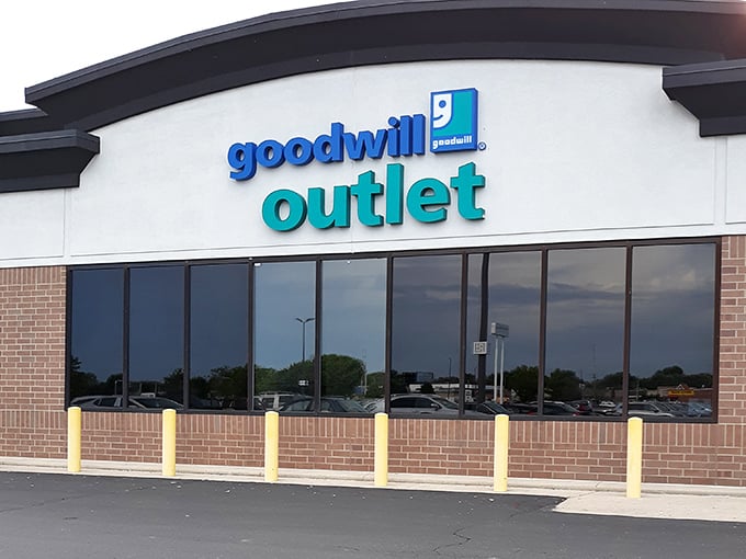 The blue and teal signage beckons bargain hunters like a retail lighthouse. Those yellow bollards have witnessed countless victory dances of shoppers who scored big.