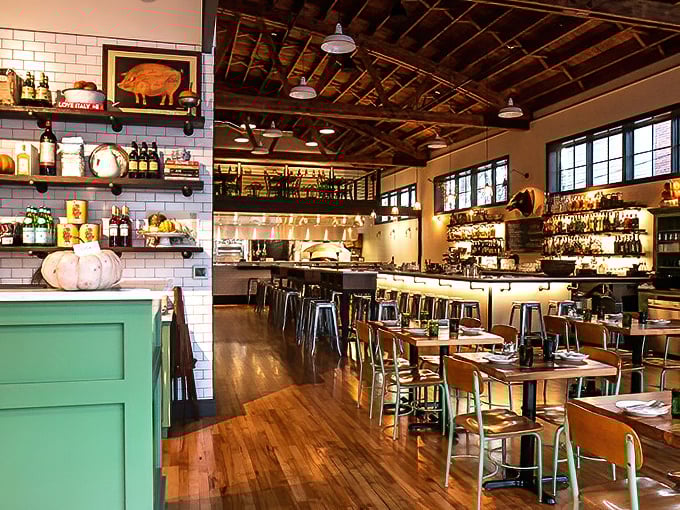 The interior feels like that perfect Italian film set—exposed beams above, polished wood below, and everywhere the promise of something delicious about to happen.