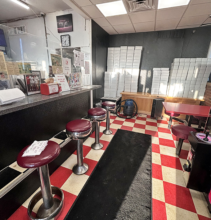 Classic red and white checkered floors and vintage counter stools – this isn't interior design, it's time travel with sprinkles on top.