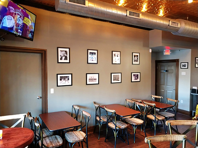 Exposed ductwork meets warm wood tones in this cozy dining space. The black and white photos aren't just decoration—they're a visual love letter to St. Louis.