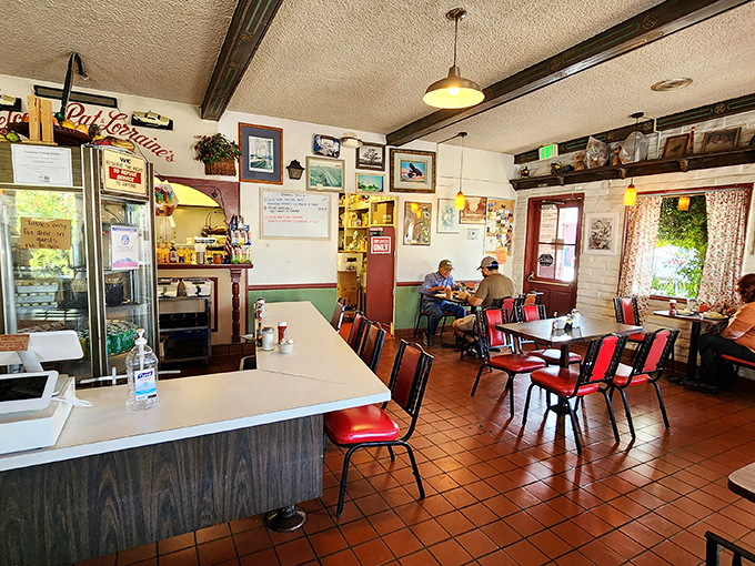 Classic diner ambiance at its finest—red chairs, terra cotta floors, and walls adorned with memories create the perfect backdrop for morning conversations.