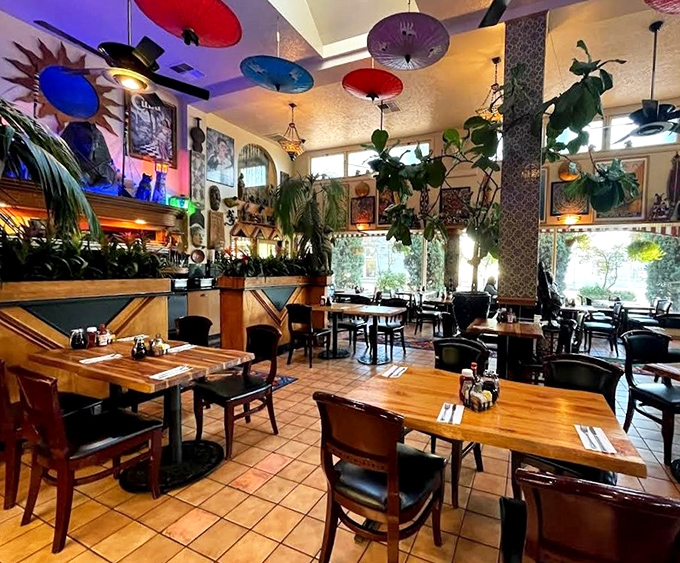 Colorful parasols float overhead like a Wes Anderson dream sequence, while plants cascade from every corner of this delightfully maximalist dining room.